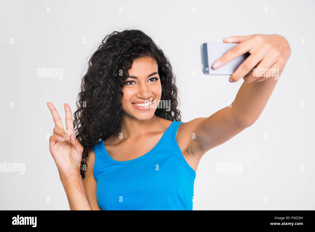 Portrait of a smiling afro american woman making selfie photo while ...
