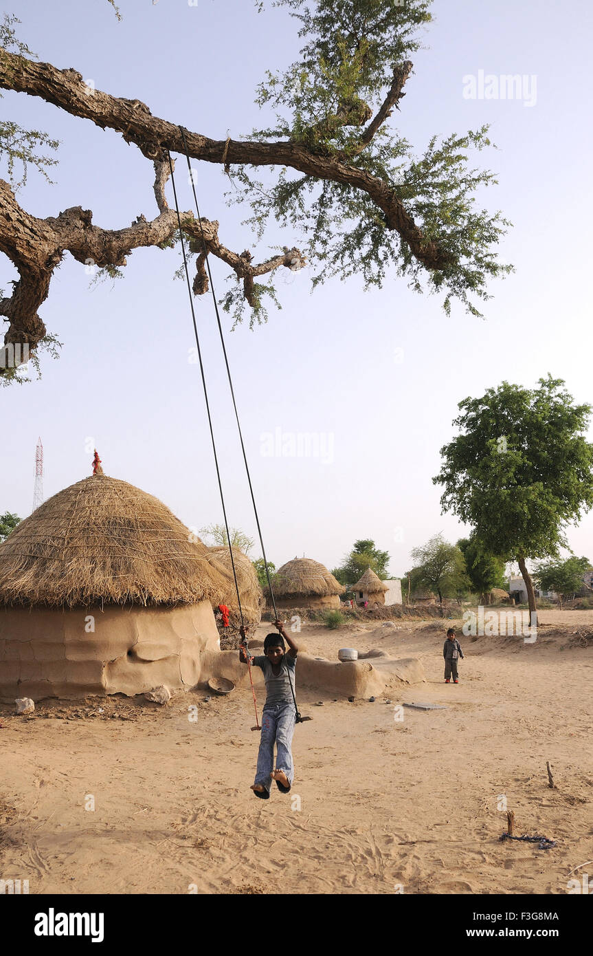 Boy swinging hanging on tree ; Sujangarh ; Rajasthan ; India Stock ...