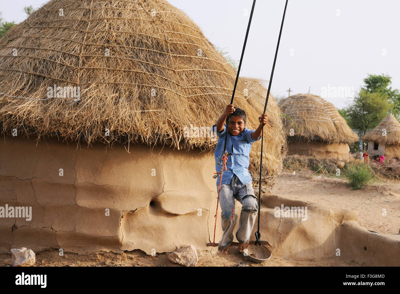 Boy swinging ; Sujangarh ; Rajasthan ; India Stock Photo - Alamy