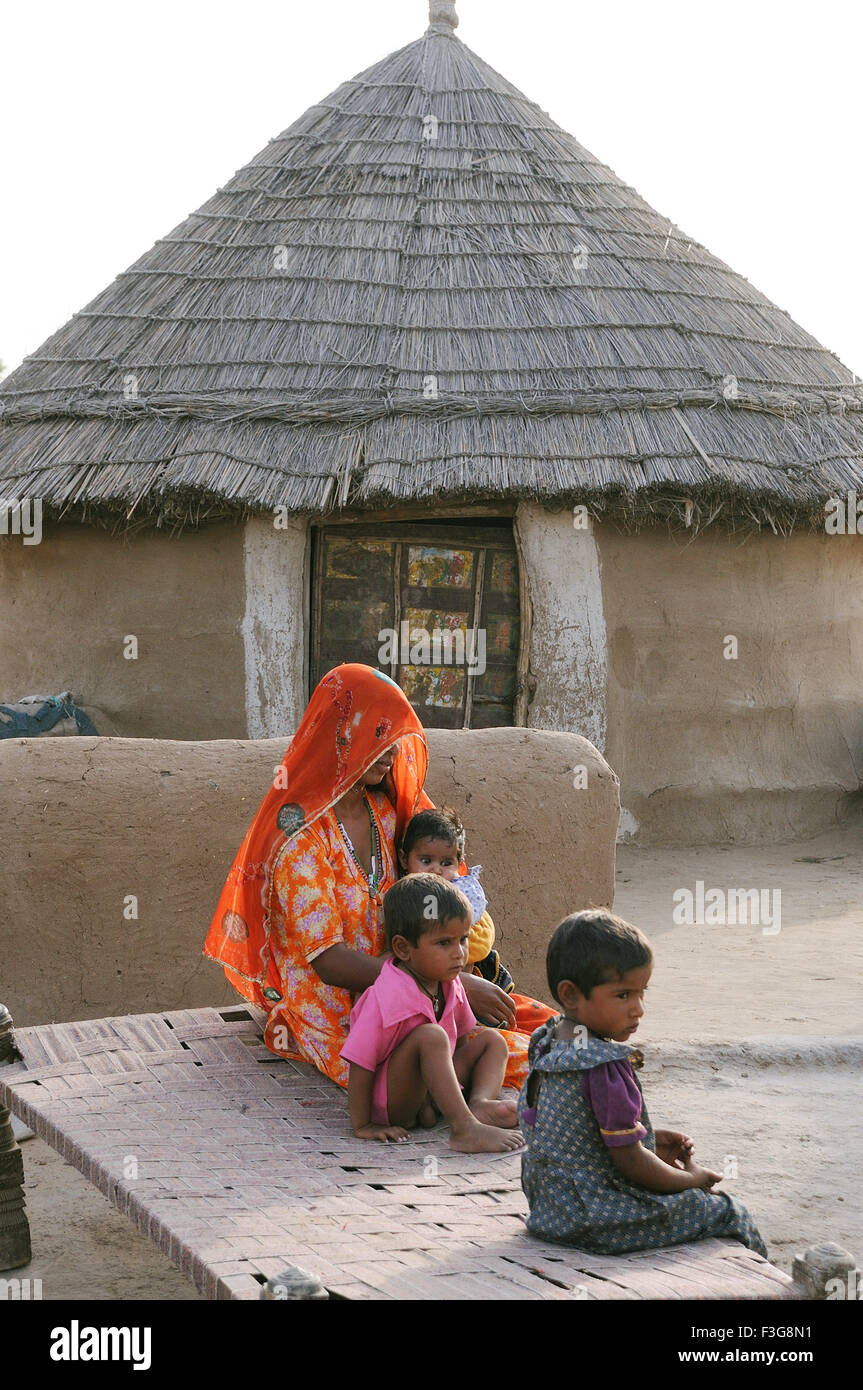 Rural Rajasthani lady sitting with her children ; Sujangarh ; Rajasthan ...