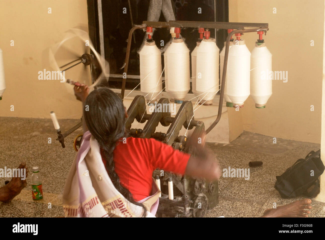 Woman working on modern spinning wheel at Gandhi Memorial ; Kanyakumari ...