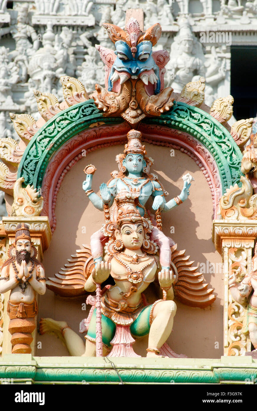 Colourfully painted sculptures of lord Vishnu sitting on Garuda ...