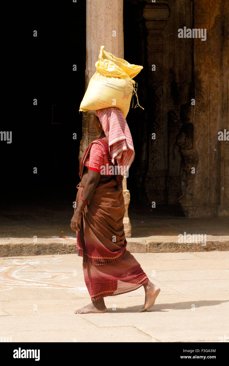 Woman carrying very heavy sand sack on head ; restoration work at Sri ...