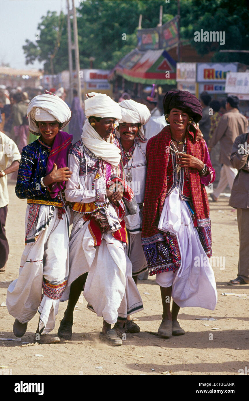 Rural men walking at Ravechi fair ; Rapar ; Kutch ; Gujarat ; India ...