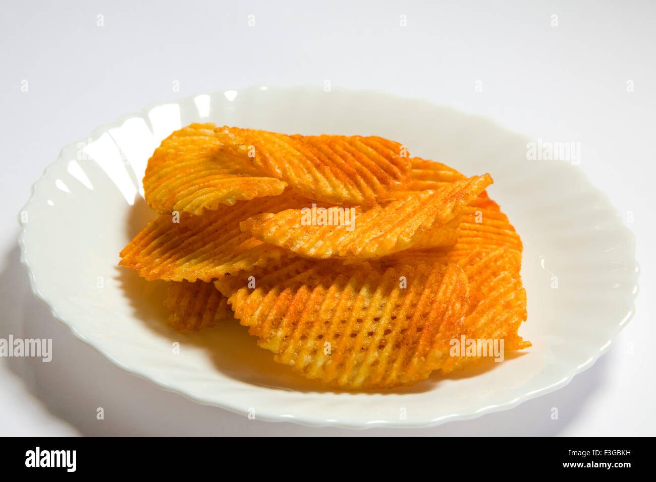 Junk food snacks salty and spicy potato chips or wafer served in plate ...
