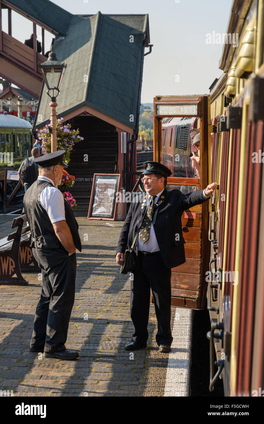Train guards stand talking whilst waiting to depart from Bewdley on the ...