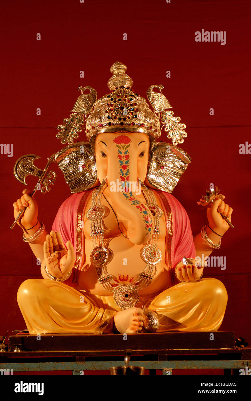 Idol of Lord Ganesh ganpati with peacock crown made of gold and gems ...