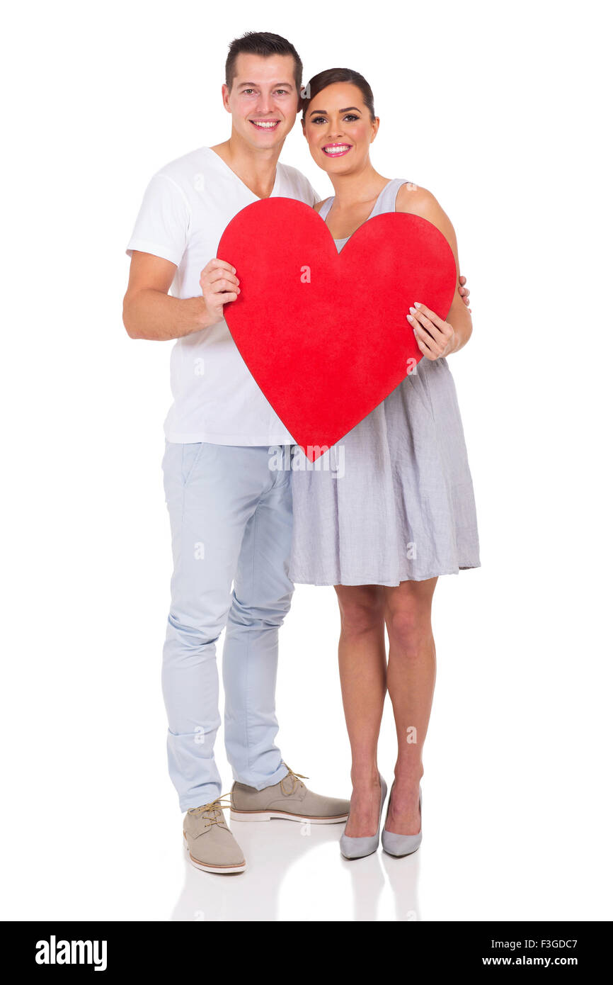 lovely young couple holding red heart symbol over white background ...