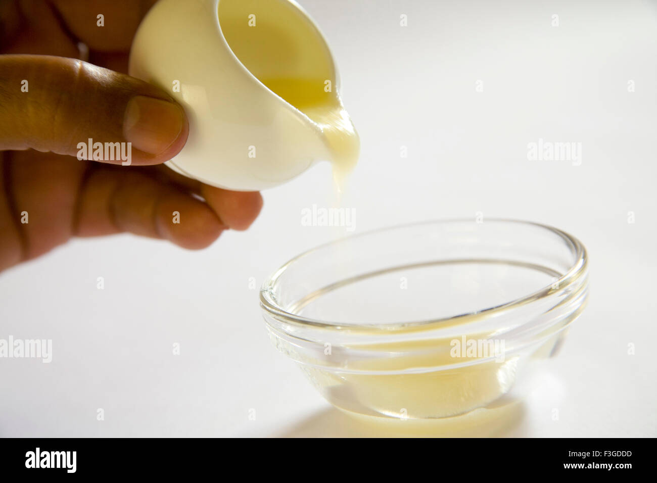 Hand pouring homemade ghee or dairy product in bowls Stock Photo - Alamy