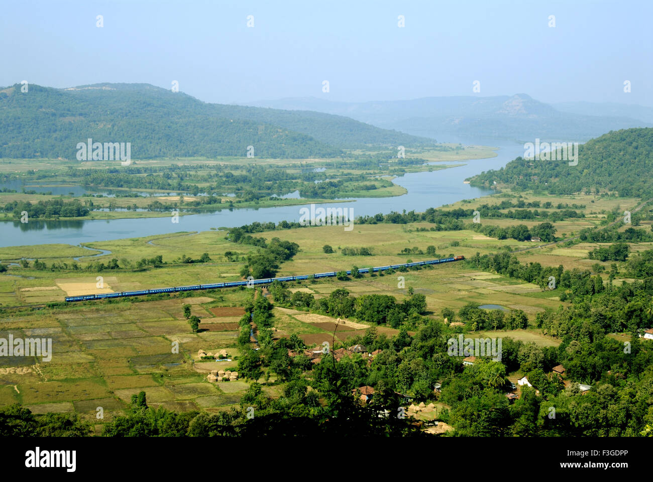 Konkan railway train passing green fields near Vasishta river at ...