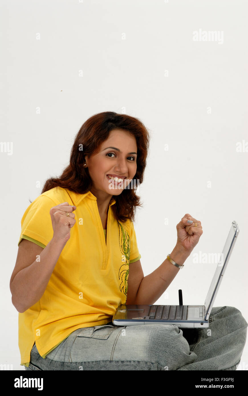 Woman working on laptop computer with raised clenched fist MR#682M ...