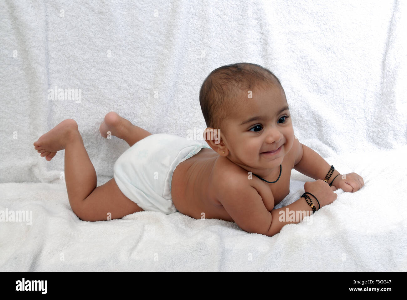 Indian baby boy child in diaper nappy underwear lying stomach tummy ...