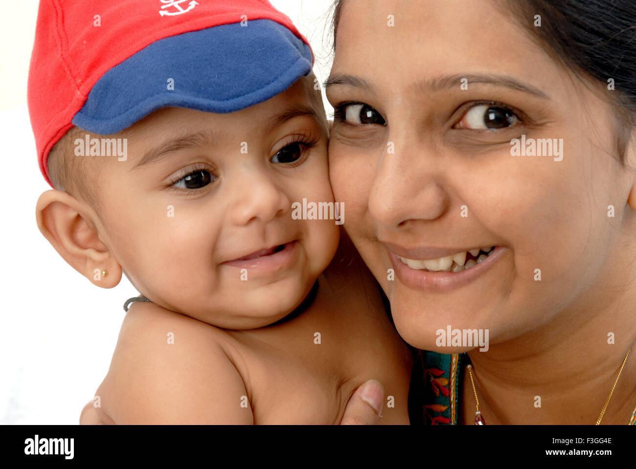 Indian mother and baby child cheeks touching on white background - MR ...