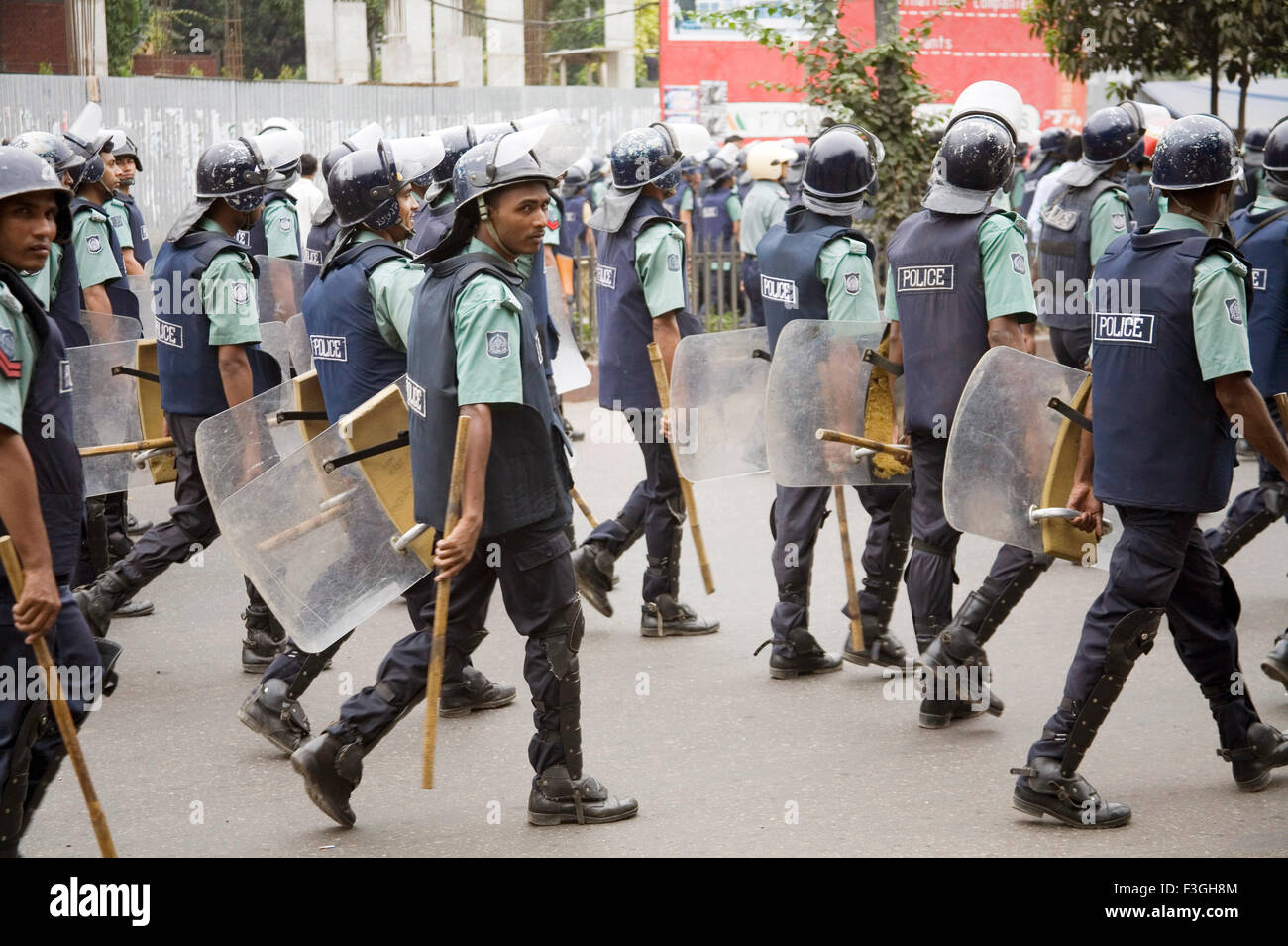 Police wearing blue uniform marching with stick on road to control the ...