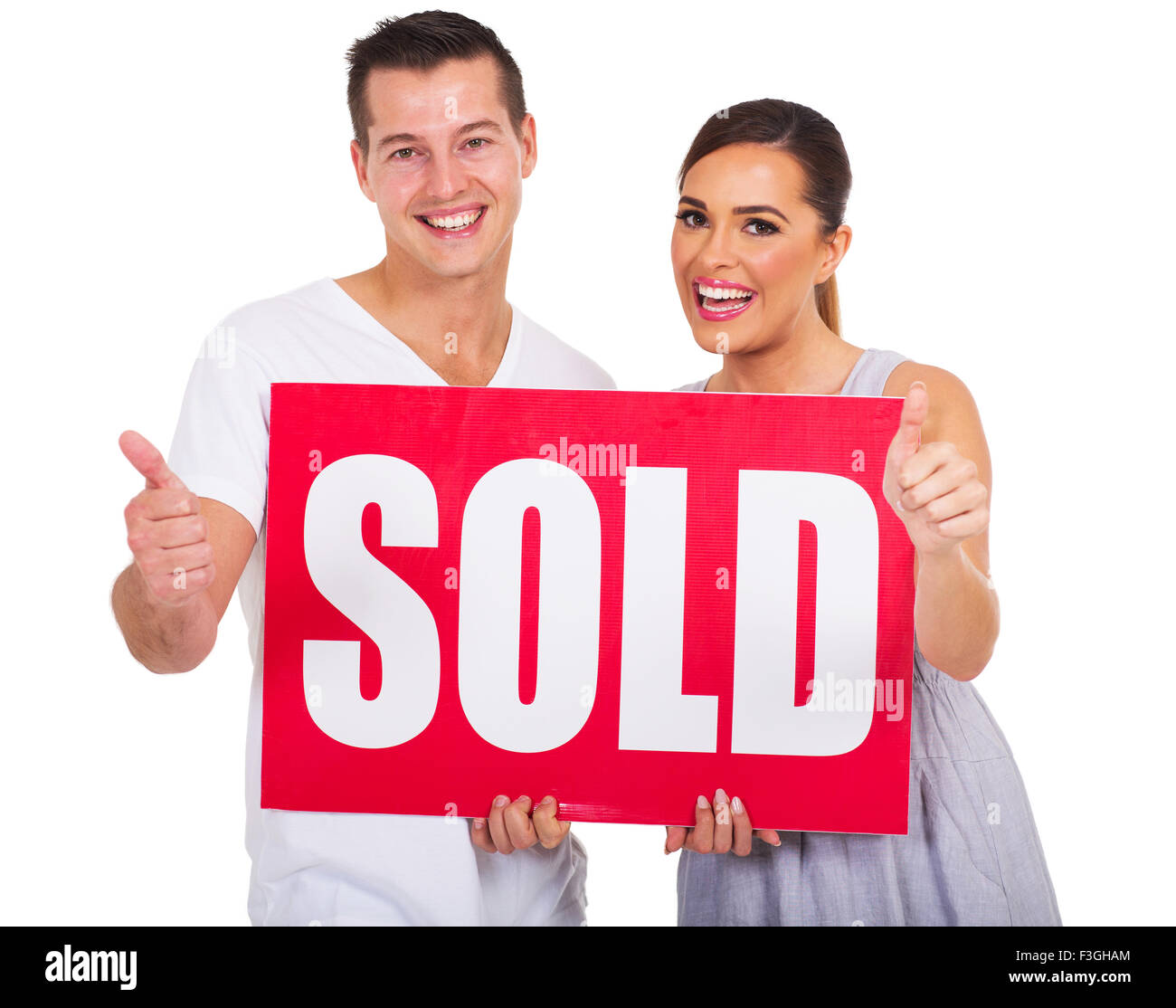 happy couple holding sold sign and giving thumbs up Stock Photo - Alamy