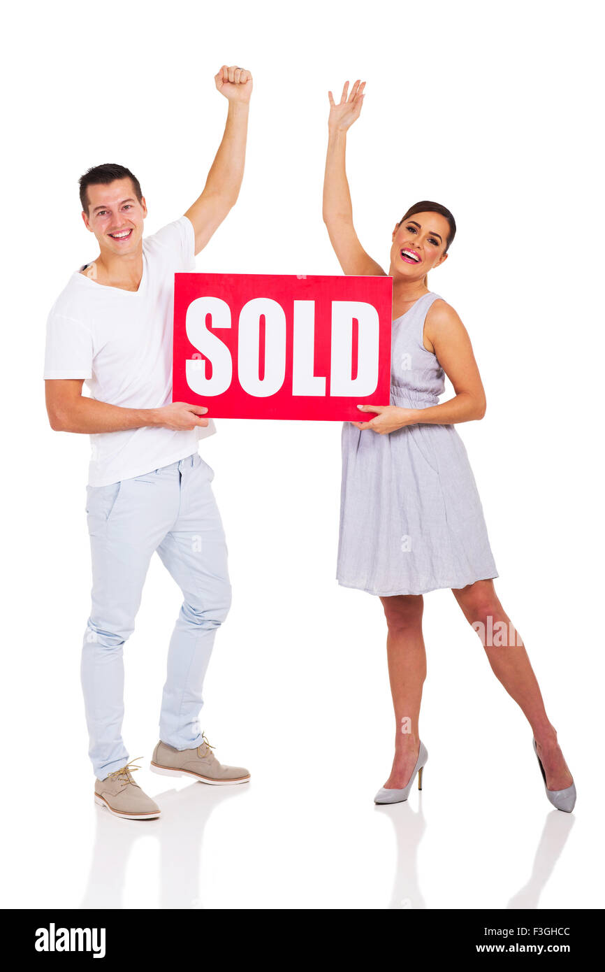 excited young couple holding sold sign isolated on white background ...