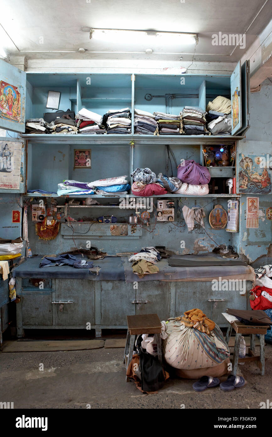 A "dhobi" ; laundryman sets up his shop in the passage of a building to ...