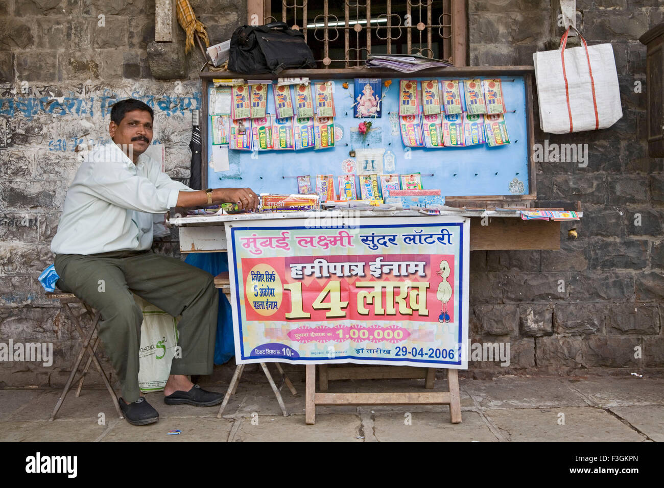 A hawker selling lottery tickets displayed on his temporary shop on the ...