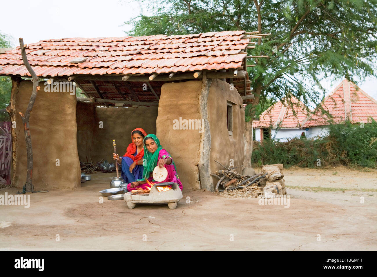Women cooking food on a wood fired earthen stove outside her house ...