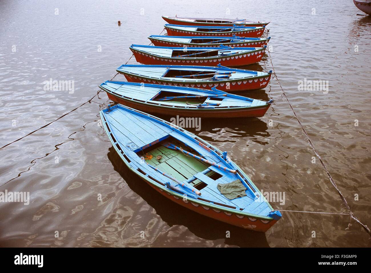 Wooden boats floating in ganga river ; Varanasi ; Uttar Pradesh ; India ...