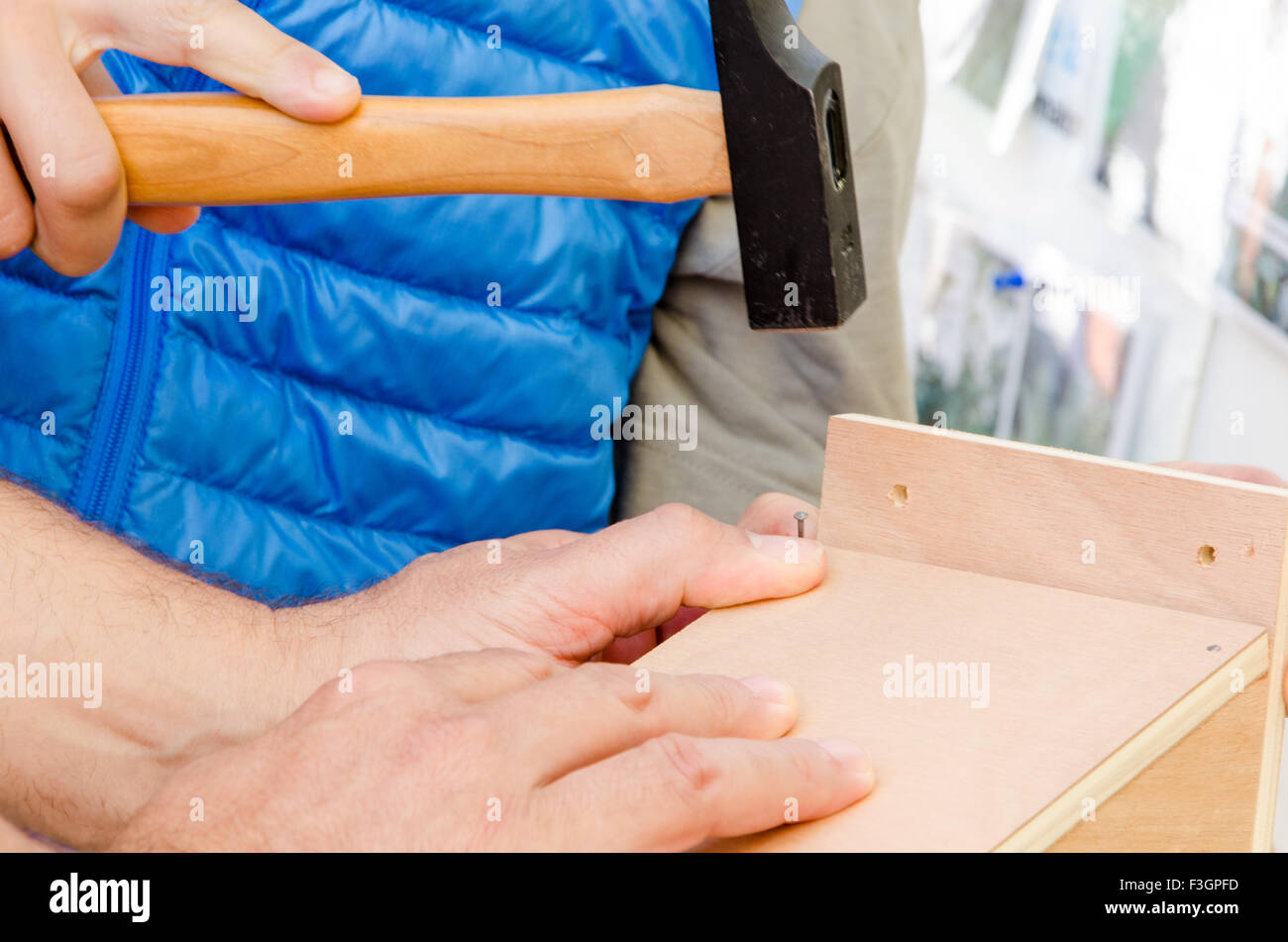 Hands and hammer on wood planks Stock Photo - Alamy
