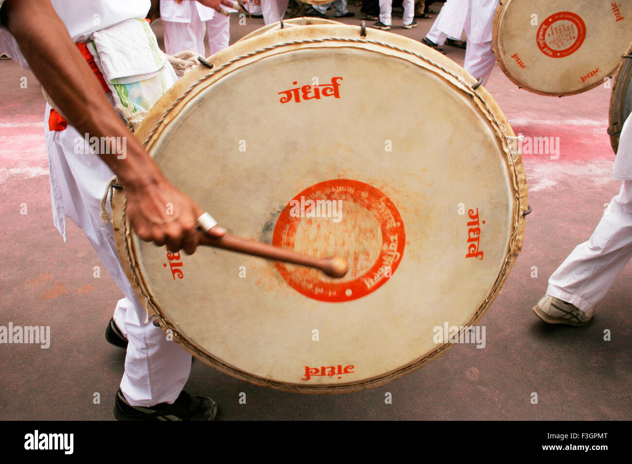 Man playing musical instrument dhol during immersion of Lord Ganesh ...