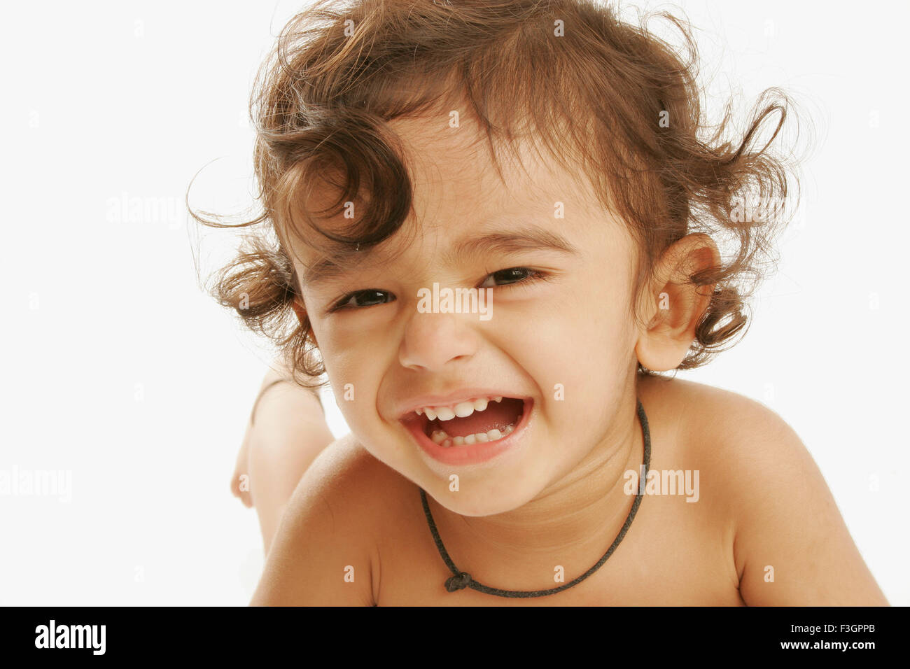 Marwari one year old boy lying on his stomach and laughing innocently ...