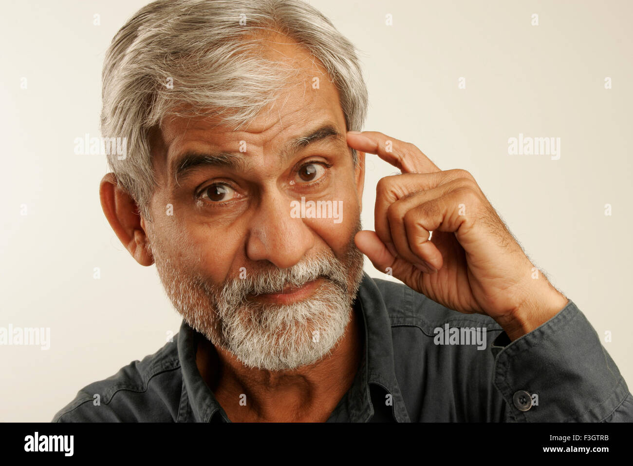 old man late fifties with gray hair beard wearing blue shirt indicating ...
