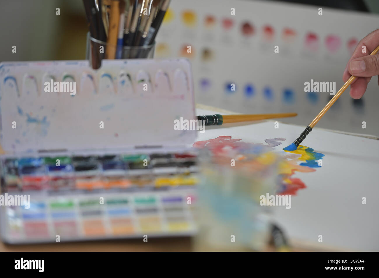 Artist's hand applying paint gouache on the drawing sheet Stock Photo ...
