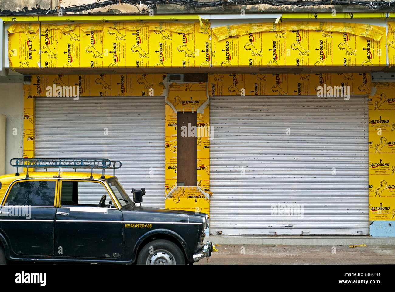 Empty taxi waiting outside closed store with yellow panels Matunga ...