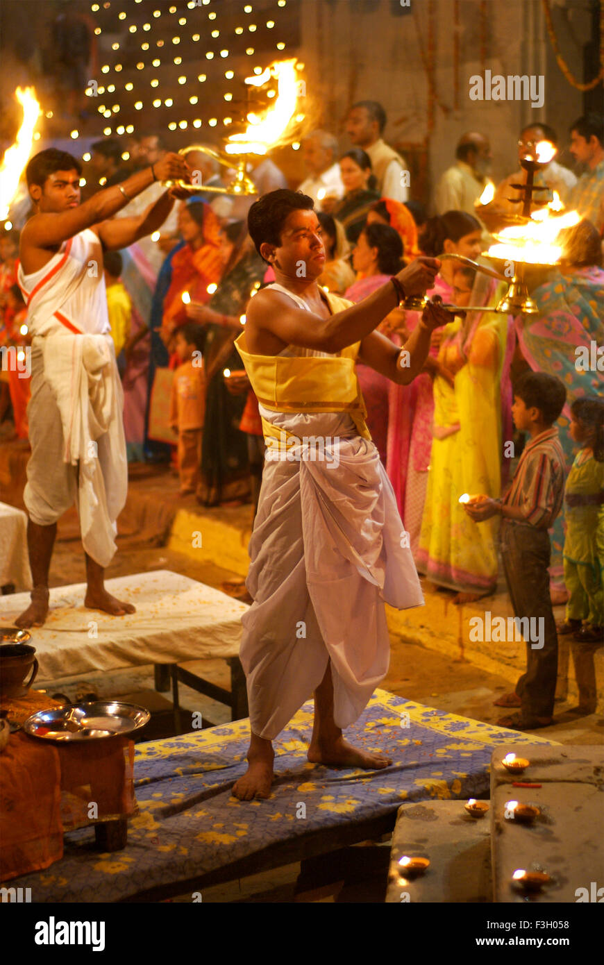 Young priest performing ganga pooja at ghat on banks of holy Ganga ...