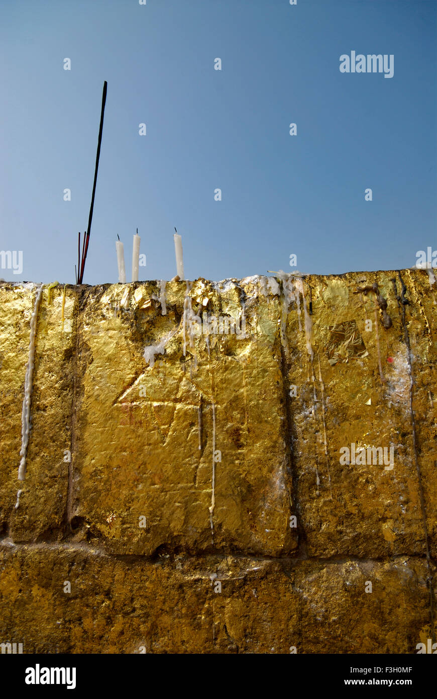 Melted candle wax and gold leaves pasted on walls of shrine of ruined ...