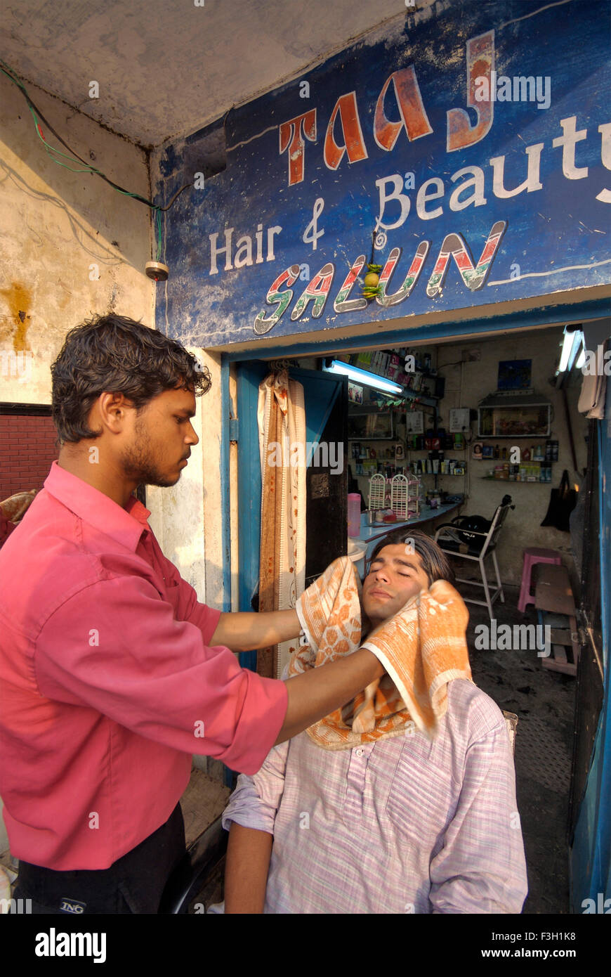 A Young man getting his facial done at Taj hair and beauty saloon ...