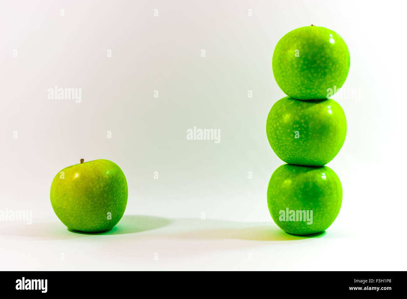four green apples on white background Stock Photo - Alamy