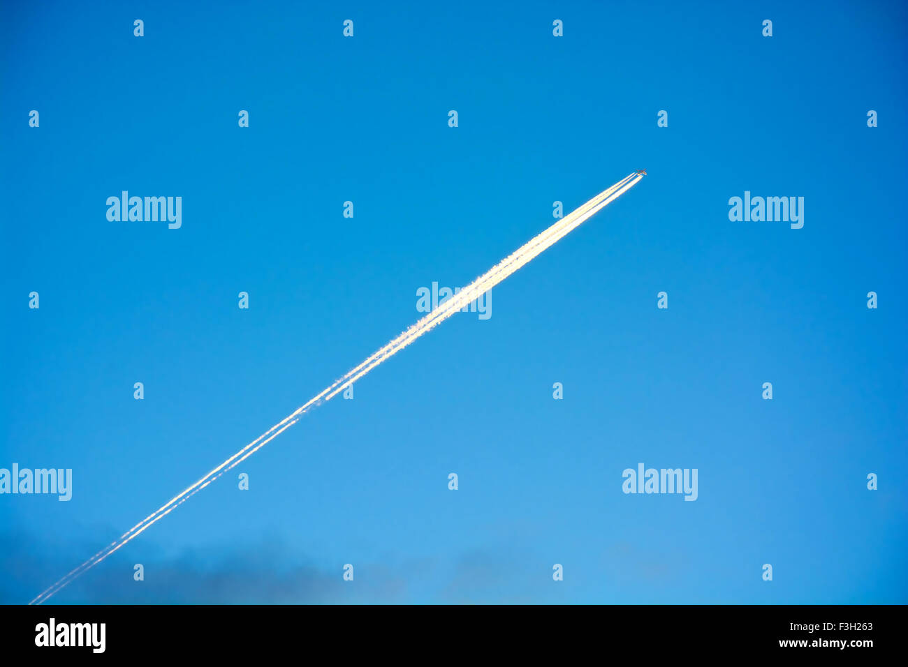 Plane and plane trails on the blue clean sky Stock Photo - Alamy