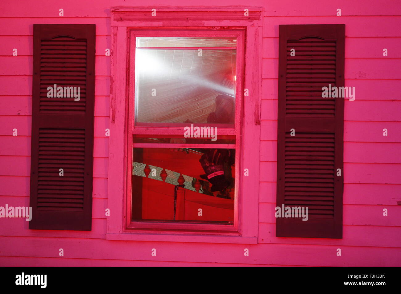 A firefighter is seen through a window looking for the source of a ...
