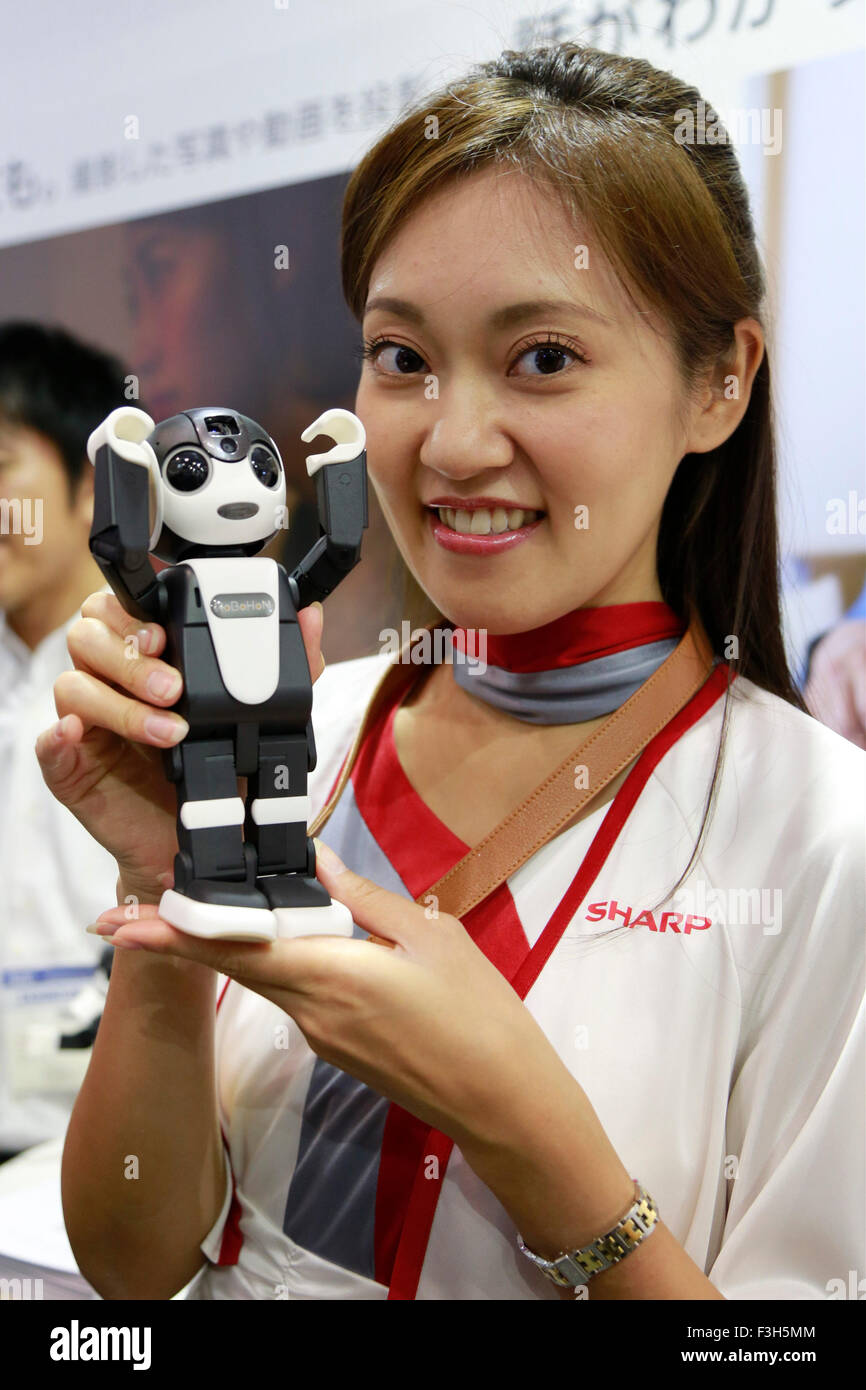 An exhibitor poses with the Sharp's RoBoHoN smartphone at CEATEC Japan ...