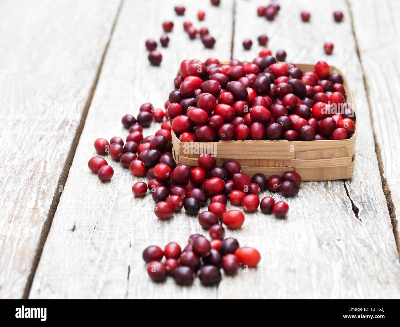 Cranberries in vintage crate on whitewashed wooden table Stock Photo ...
