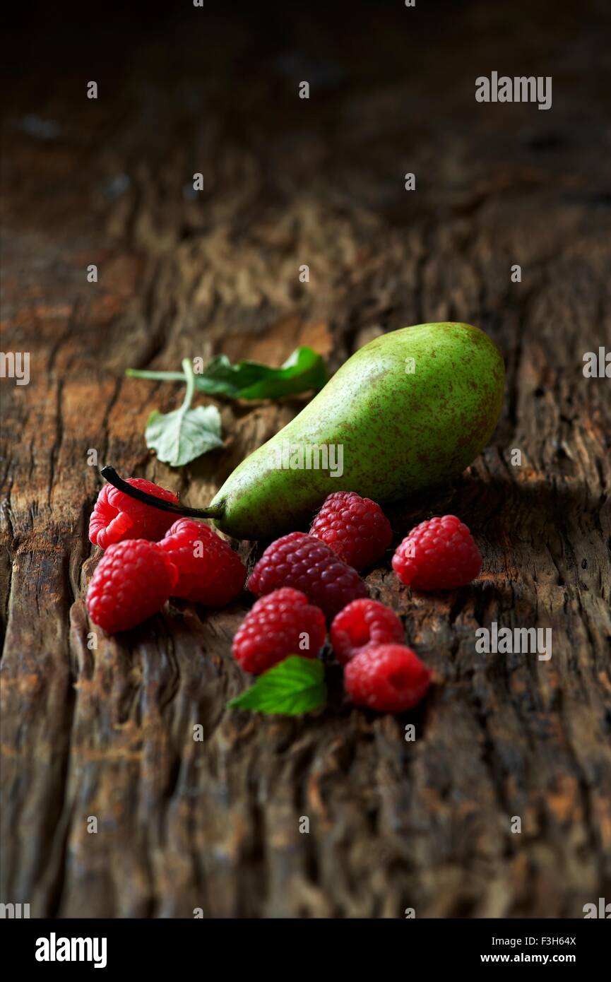 Pears and raspberries on old wooden surface Stock Photo - Alamy