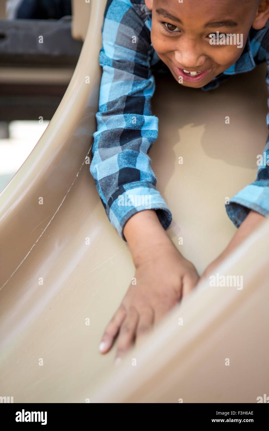Boy playing on slide Stock Photo - Alamy