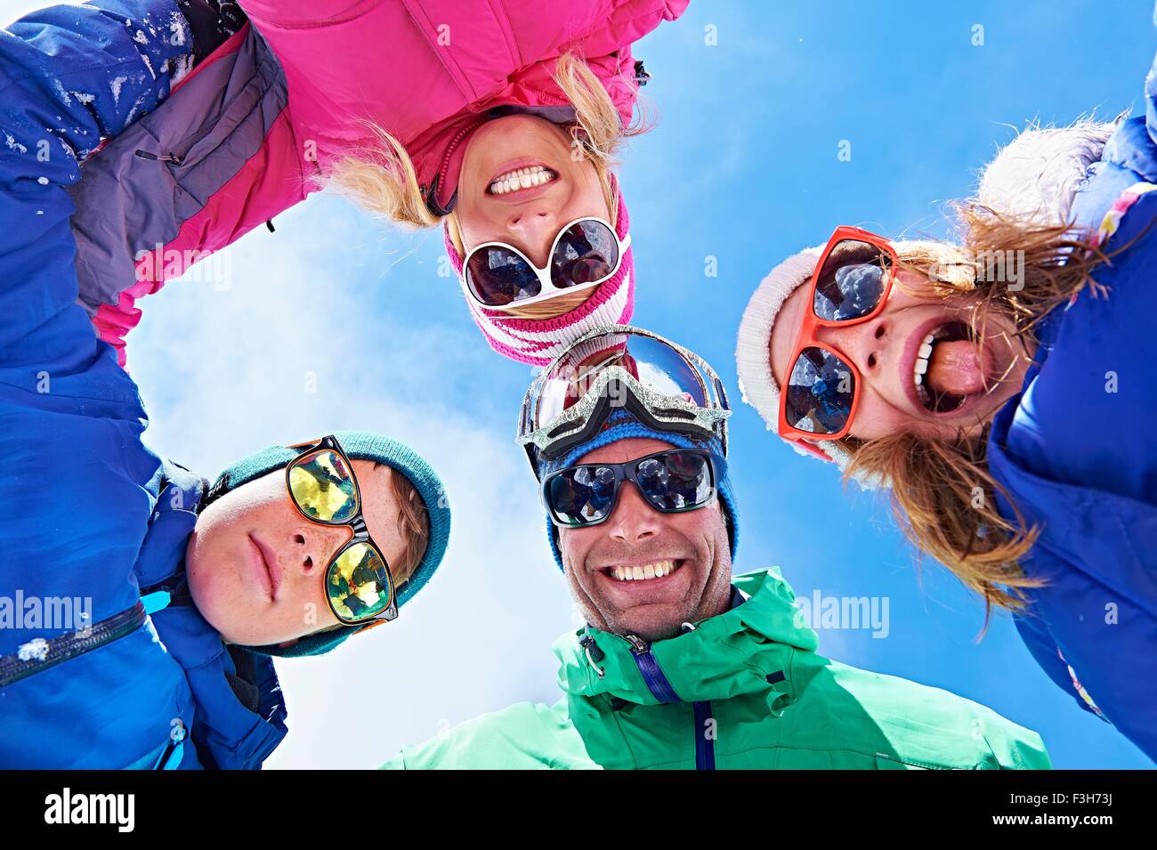 Low angle view of family in winter clothing and sunglasses Stock Photo ...