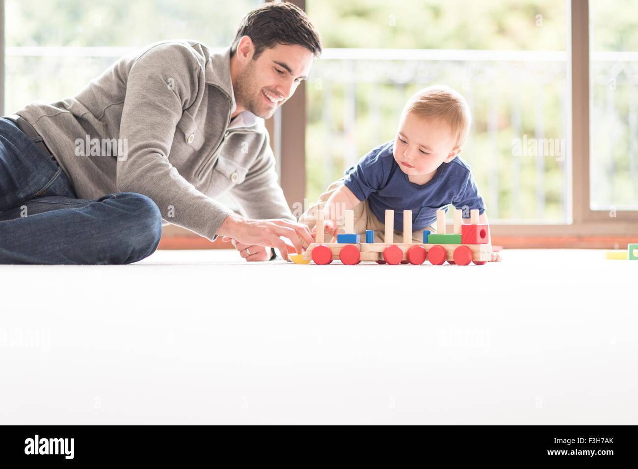 Father and young son playing together, indoors Stock Photo - Alamy
