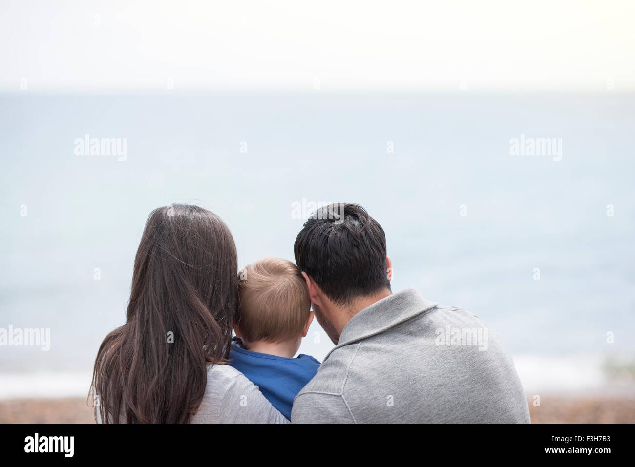 Young family looking at sea view, rear view Stock Photo - Alamy
