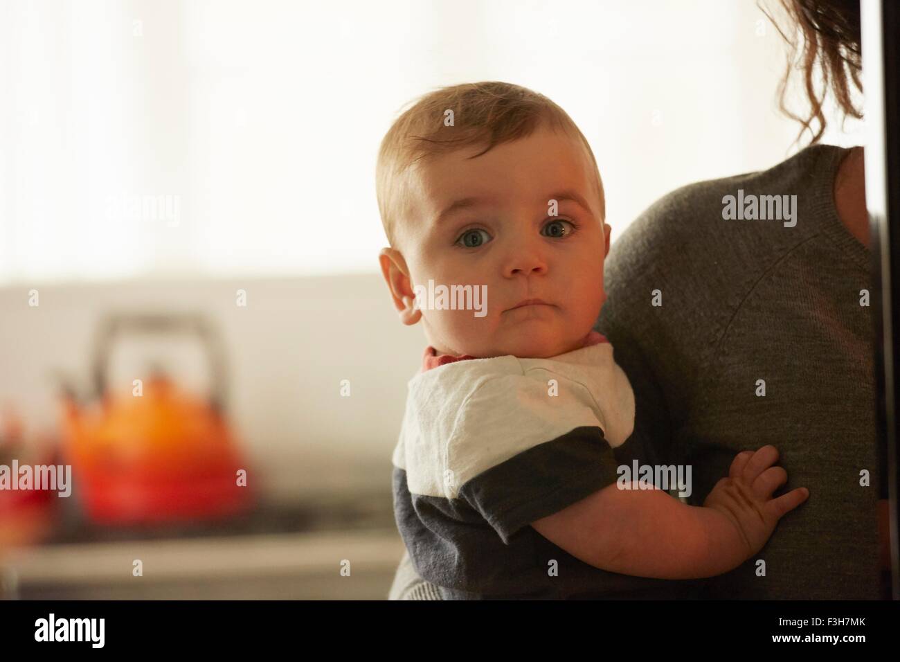 Mother carrying baby boy in kitchen Stock Photo - Alamy