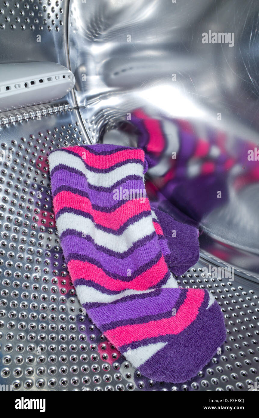 Pink multi coloured sock in washing machine Stock Photo - Alamy