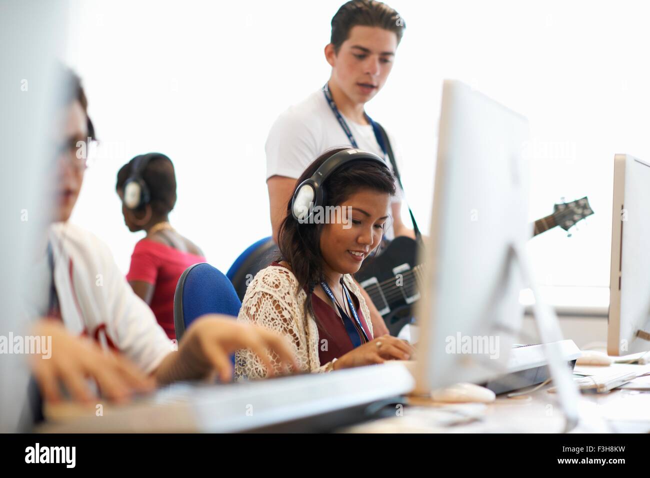 Female college student wearing headphones playing keyboards looking ...