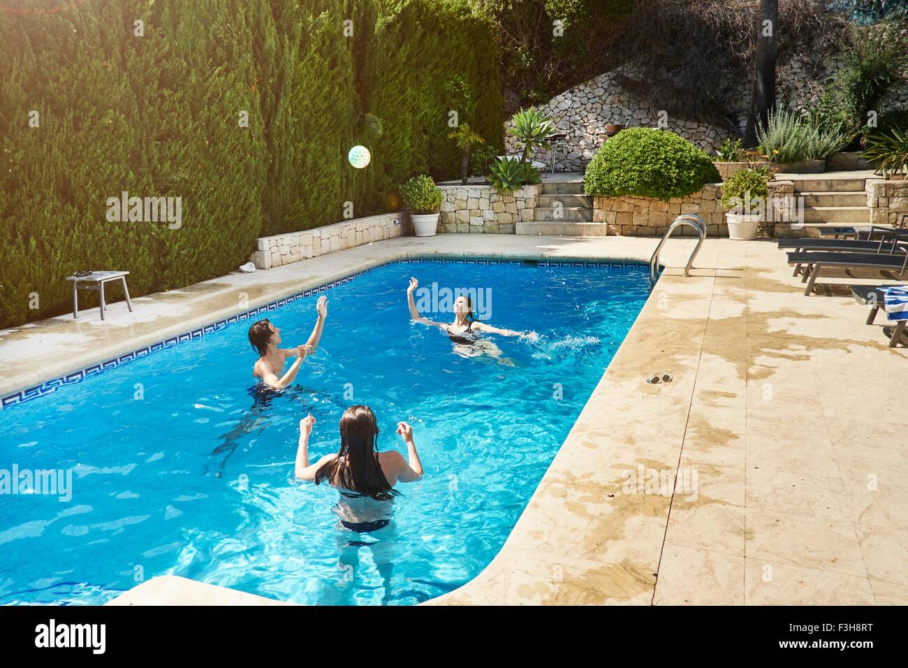 Mature woman throwing ball with son and daughter in swimming pool Stock ...