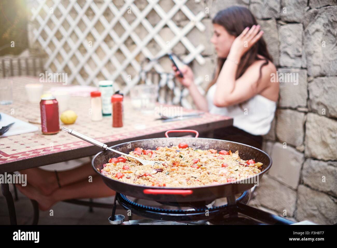 Teenage girl texting on smartphone at patio lunch table Stock Photo - Alamy