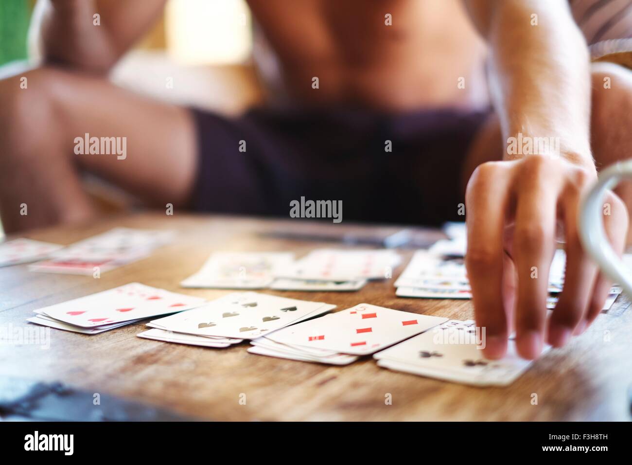 Cropped shot of young man playing cards at table Stock Photo - Alamy