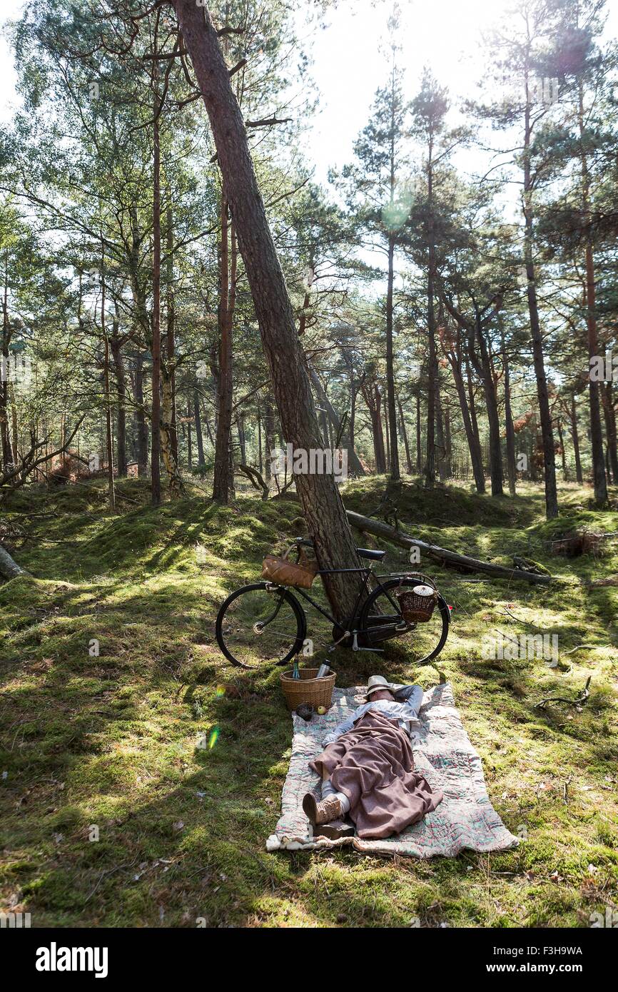 Mature female forager lying on blanket in forest Stock Photo - Alamy